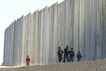 Palestinian children are dwarfed by the massive wall in Bethany. The ...
